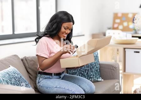 african american woman opening parcel box at home Stock Photo - Alamy