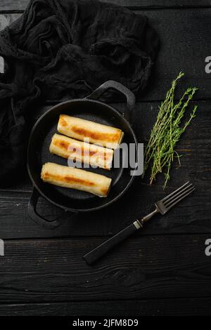 Georgian crepes stuffed on black wooden table background, with copy ...