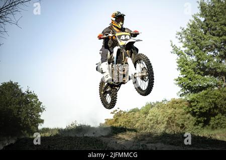 Live shot of male sportsman training on motorbike at hot summer day ...