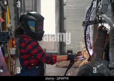 Female mechanic protecting eyes while welding metal Stock Photo - Alamy