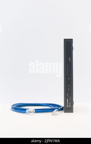 TP-LINK gigabit broadband network router with network cables on a white ...