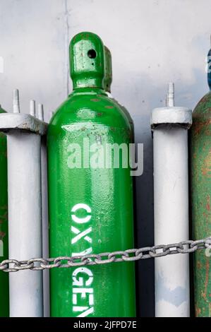 Compressed gas cylinders being stored vertically secured by a metal ...