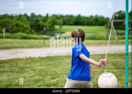 Tetherball being hit and roped in a game with a young boy Stock Photo ...