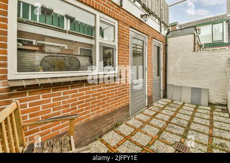 Neat paved patio with sitting area and small garden near wooden fence ...