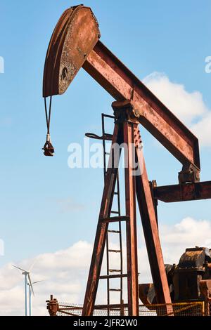Oil pumping machine and windmills. Petroleum extraction. Resource Stock ...