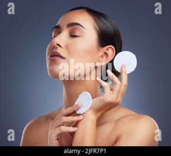Beautiful hispanic woman holding cotton pad and make up remover ...