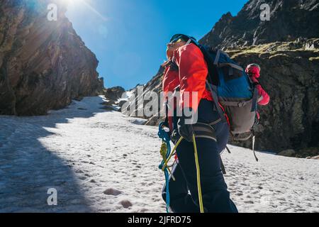 Team roping up woman dressed high altitude mountaineering clothes and ...