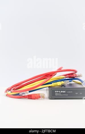 TP-LINK gigabit broadband network router with network cables on a white ...