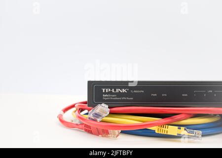 TP-LINK gigabit broadband network router with network cables on a white ...