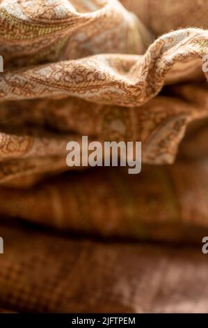 Pieces of fabric with different patterns, stacked. Close-up, selective ...