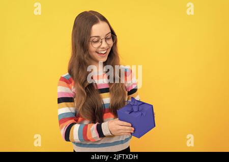 surprised teen girl hold present box on yellow background Stock Photo ...