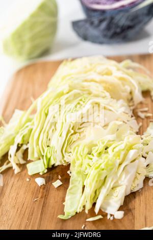 Shredding green cabbage on a wood cutting board Stock Photo - Alamy
