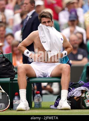 Cameron Norrie changes his shirt during his Gentlemen's Singles quarter ...