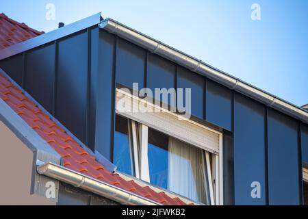 Newly tiled roof with large dormer with standing seam cladding Stock ...