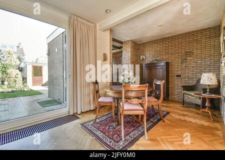 Comfortable couch located near carpet and table against window in ...