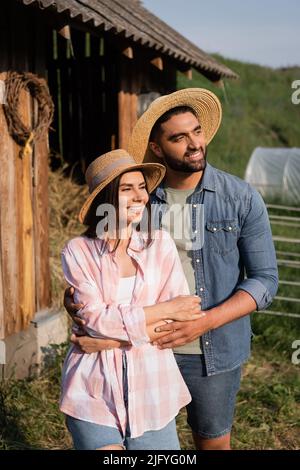 cheerful couple of farmers in straw hats smiling at camera on family ...