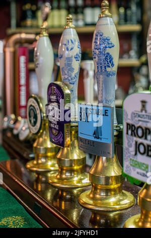 Bar pumps in an old english pub with optics on the wall Stock Photo - Alamy