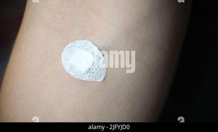 Small round patch stuck in place intravenous injection on forearm ...