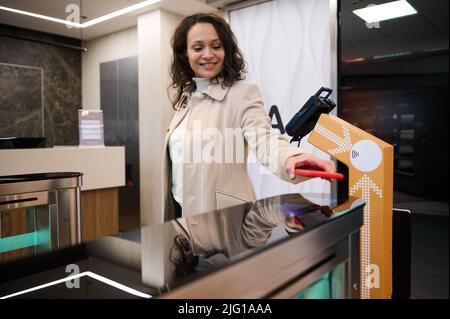 Young woman entering code at gate in urban area Stock Photo - Alamy