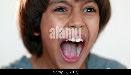 Upset child screaming. Mixed race Kid yelling roaring to camera, close ...