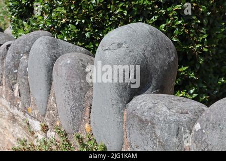 Large round stones cemented to the top of a wall as an ornamental ...