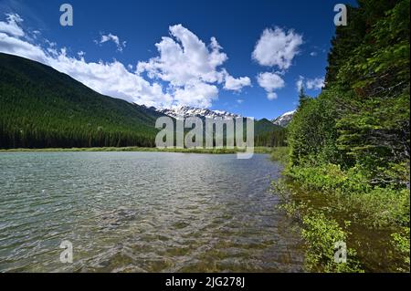 Snow-capped mountains behind Stantion Lake in Great Bear Wilderness ...