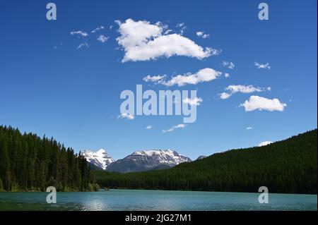 Snow-capped mountains behind Stantion Lake in Great Bear Wilderness ...