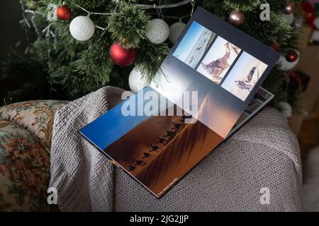 Photo book family photo album under the Christmas tree surrounded by ...