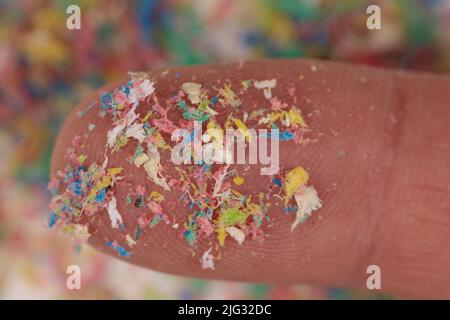Macro shot of microplastics on human finger. Concept of plastic ...