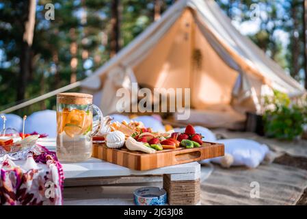 Picnic in the nature, table, carpets, wigwam, tent, pillows in the park ...