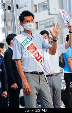 Kentaro Asahi greets pedestrians outside Tokyo Dome on July 7, 2022, in ...