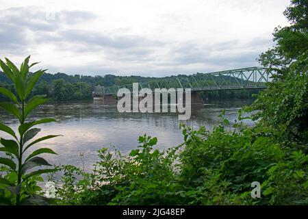 Narrow metal truss bridge crossing the Delaware River between the towns ...