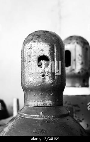 Compressed gas cylinders being stored vertically secured by a metal ...