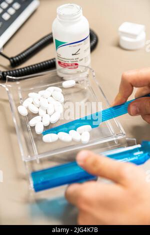 Hands, pharmacist and counting pills for drug dose, packaging or ...