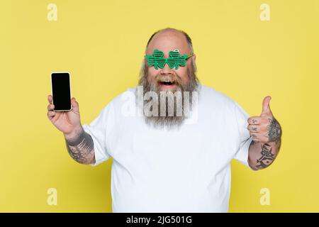 bearded overweight man in clover-shaped glasses talking on smartphone ...