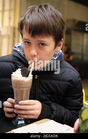 little boy holding glass of strawberry milkshake outdoors Stock Photo ...