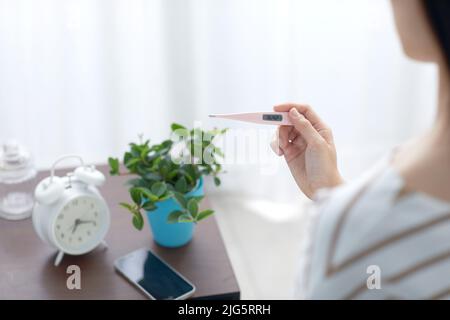 Japanese woman checking body temperature Stock Photo - Alamy