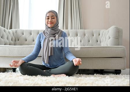 Arabic Woman Meditating Sitting In Lotus Position Over Blue Background ...