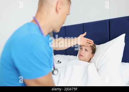 Doctor touching forehead of ill woman, examining of patient Stock Photo ...