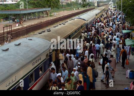 Pakistani people boarding on the roof top of a crowded train as they ...