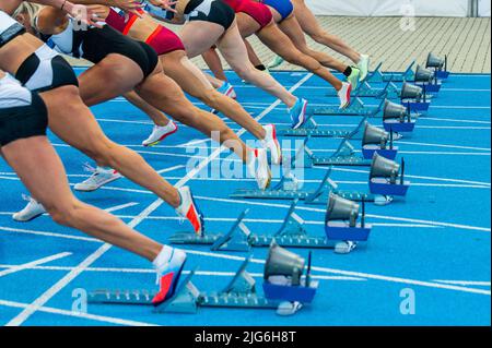 female sprinter start running from starting blocks in athletics ...