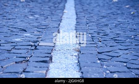 Paving stones. Cobblestone pavement divided by a granite strip close-up ...