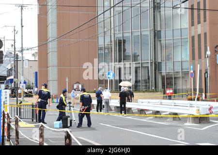 Police officers investigate the scene where Japan's former Prime ...