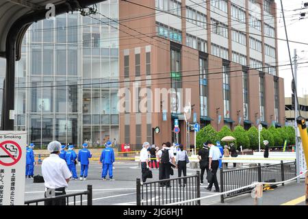 Police officers investigate the scene where Japan's former Prime ...