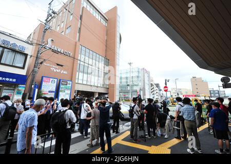 Police officers investigate the scene where Japan's former Prime ...