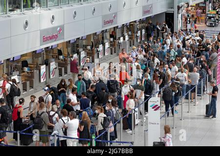 Passengers wait and queue at a Eurowings check-in desk of Cologne Bonn ...