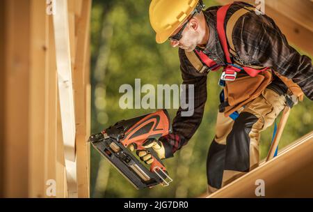 Worker is assembling wooden frame beams trusses during work day Stock ...