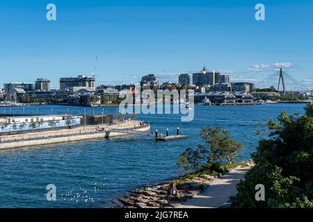 An aerial view of a harbor with Anzac Bridge in the background on a ...