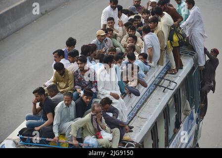 Pakistani people boarding roof top on a crowded bus as they travel to ...