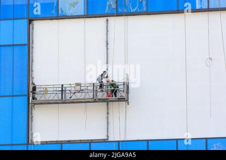 group of window washers hanging on ropes on a skyscraper facade Stock ...